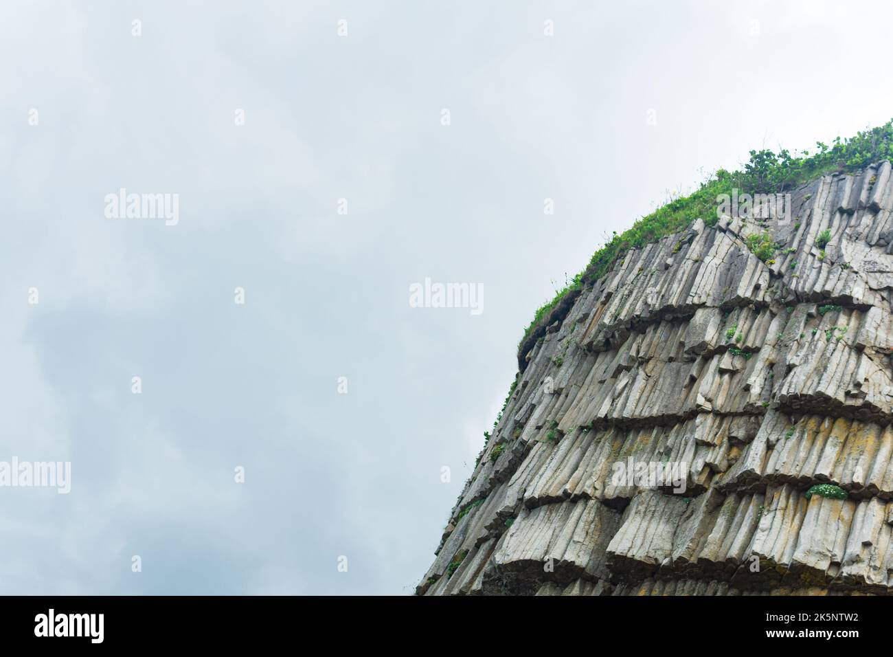 top of columnar volcanic basalt cliff against the background of the sky ...