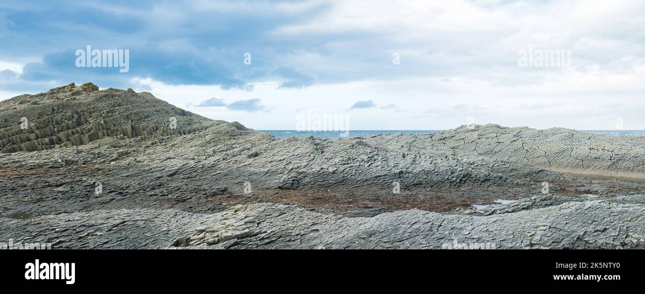 rocky seashore made of columnar granite, hardened lava, resembling ...