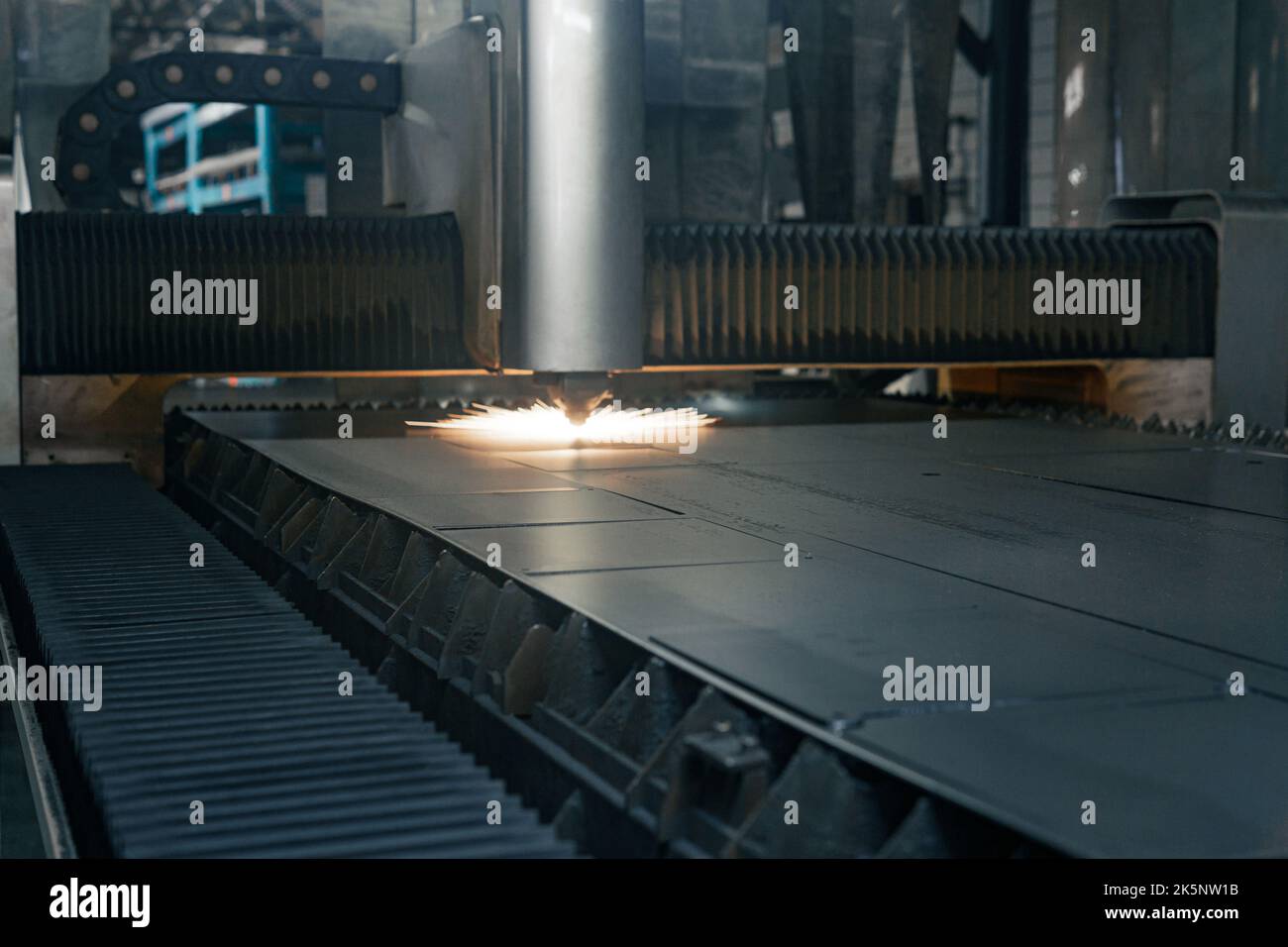 heavy industrial laser cutter during metal sheet processing, head with ...