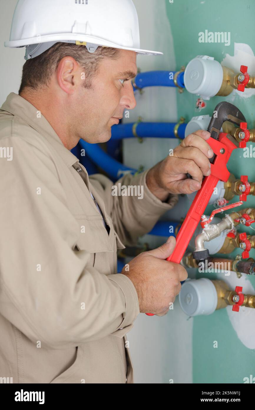 mature plumber using wrench on pipe Stock Photo - Alamy