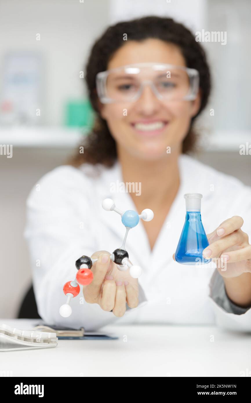 joyful female scientist holding flasks and 3d model of dna Stock Photo - Alamy