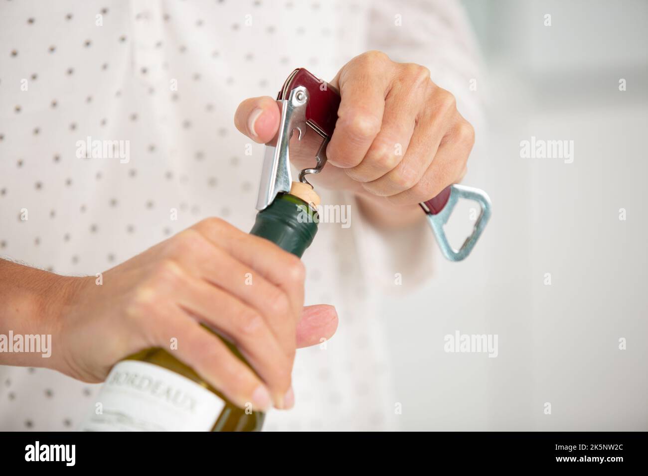 hand broaching bottles of wine Stock Photo - Alamy