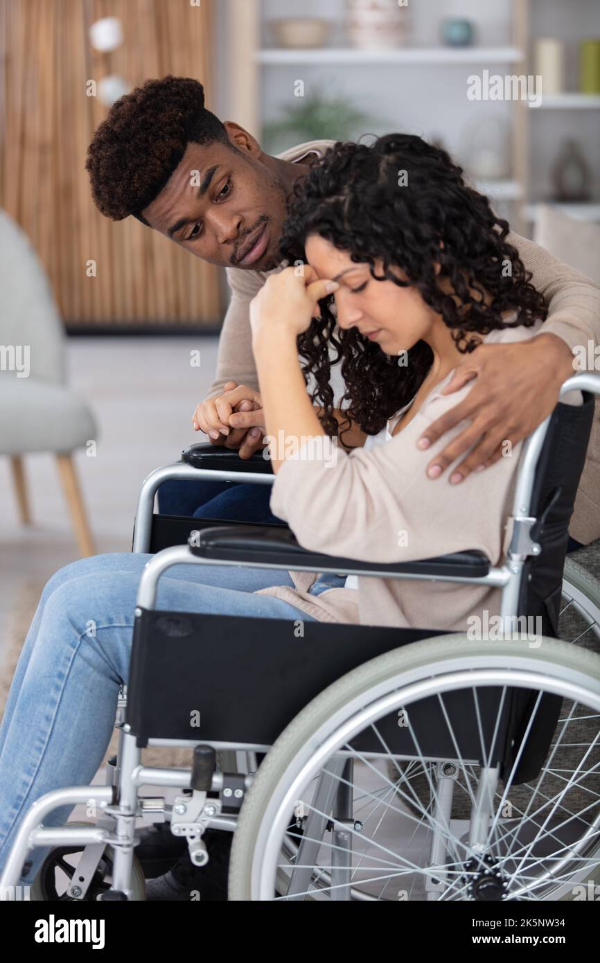 young man consoles emotional woman in a wheelchair Stock Photo - Alamy