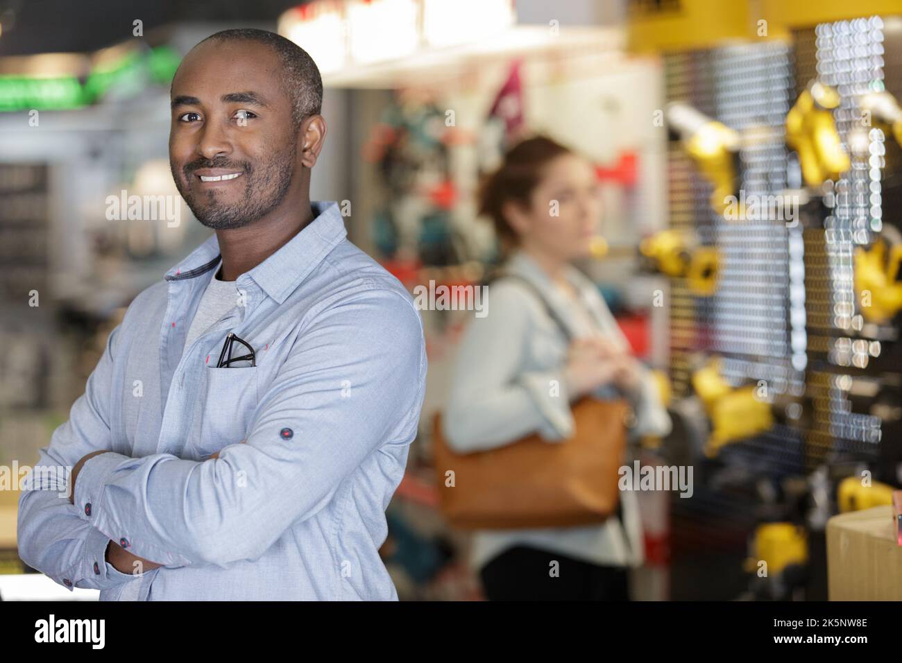 hardware store salesman standing next to shelves Stock Photo - Alamy