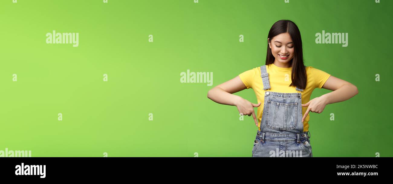 Studio shot easygoing cute asian female introduce new promo, pointing ...