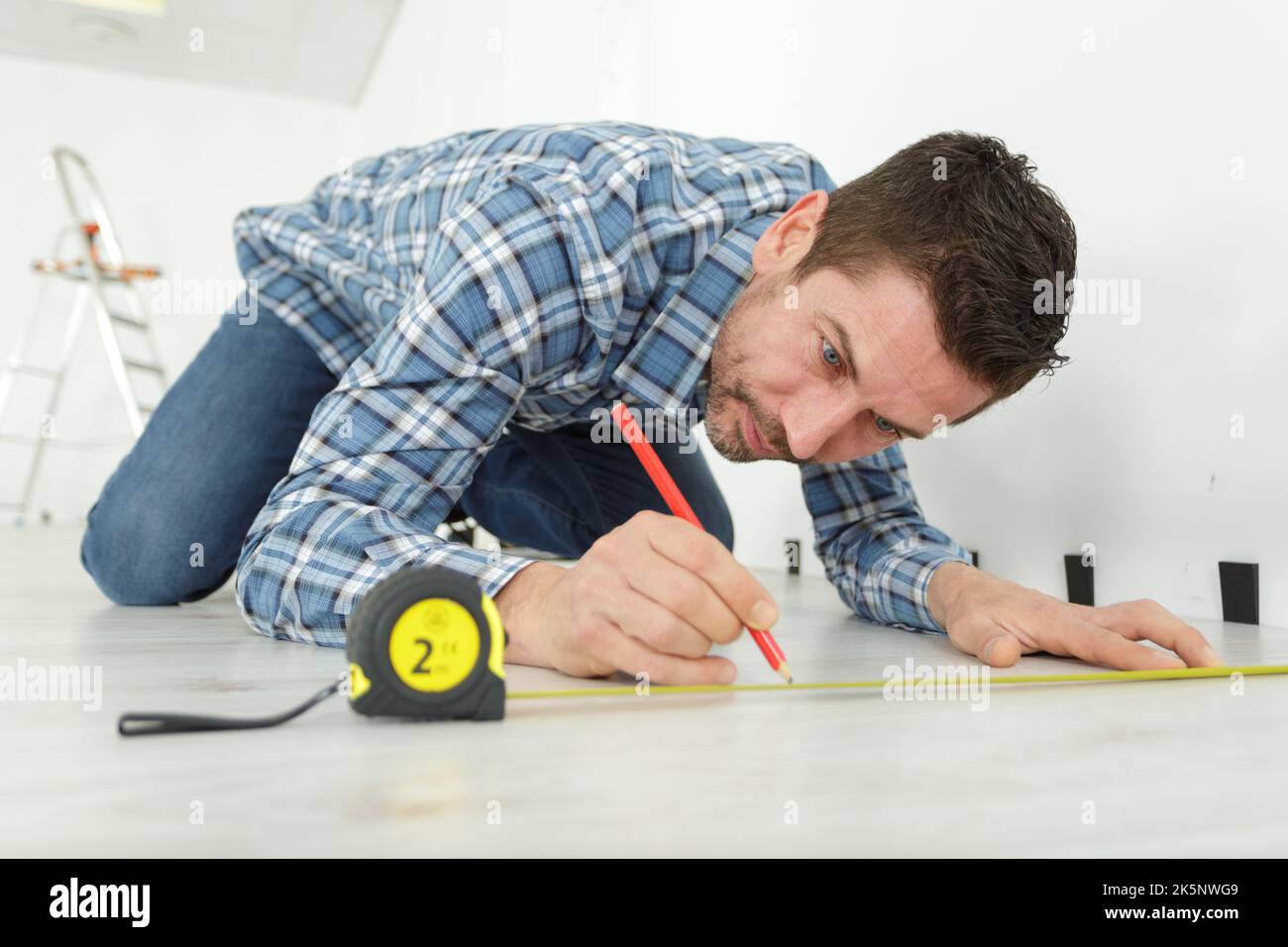 Worker makes measurements installing hi-res stock photography and ...