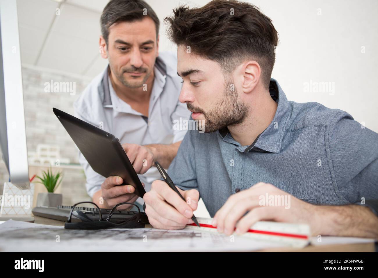 colleagues discussing an architectural drawing together Stock Photo - Alamy