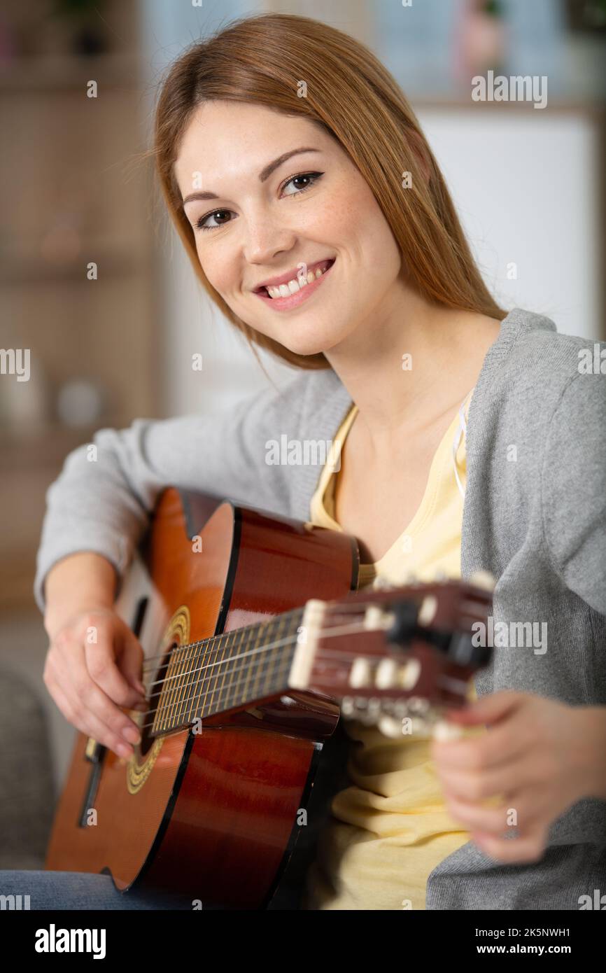 a beautiful woman smile while playing acoustic guitar Stock Photo - Alamy