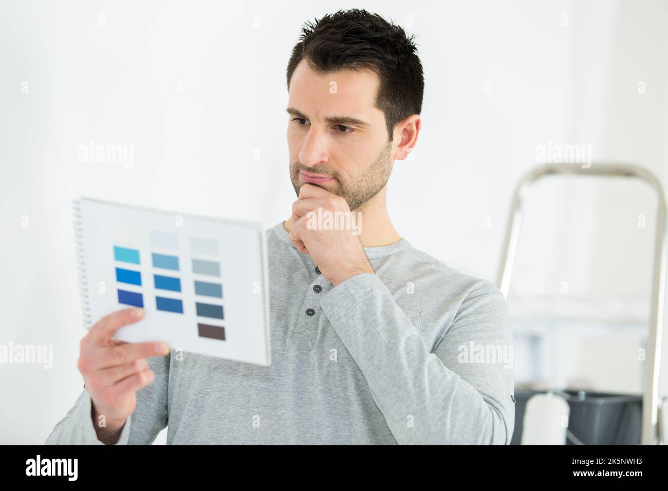 man looking at a color swatch and choosing color Stock Photo - Alamy