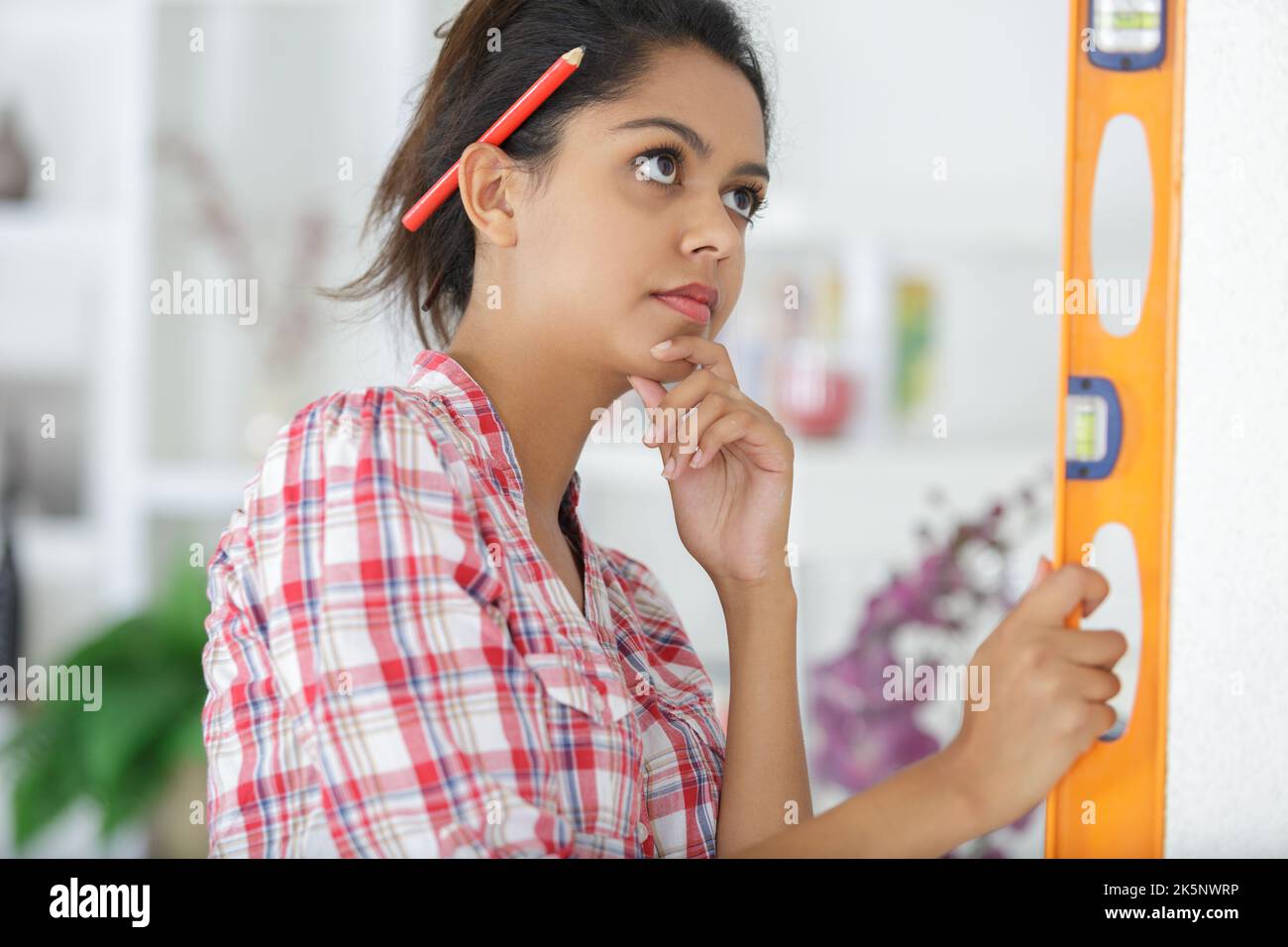 pretty young woman using a spirit level Stock Photo - Alamy