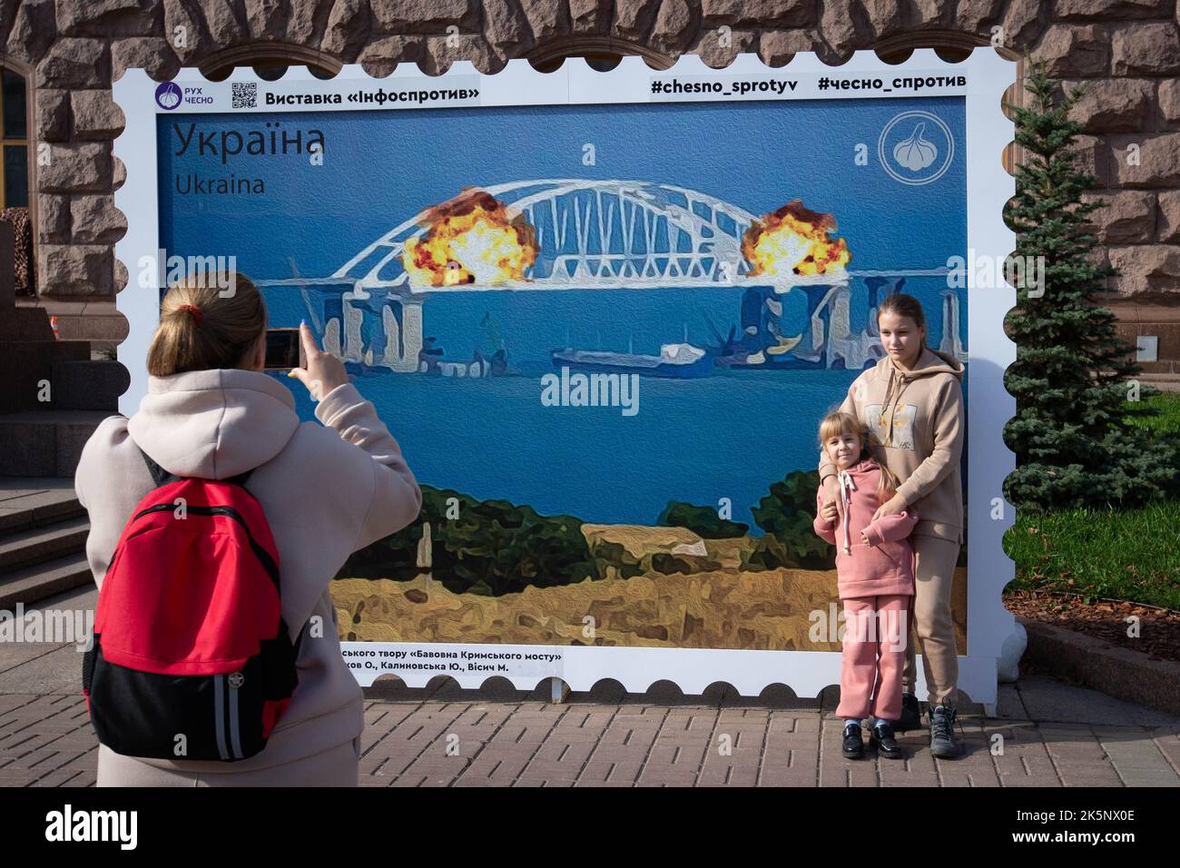 People are photographed with a stamp model depicting the burning ...