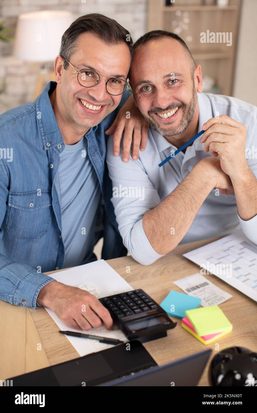 happy gay couple reading mail and checking accountancy Stock Photo - Alamy