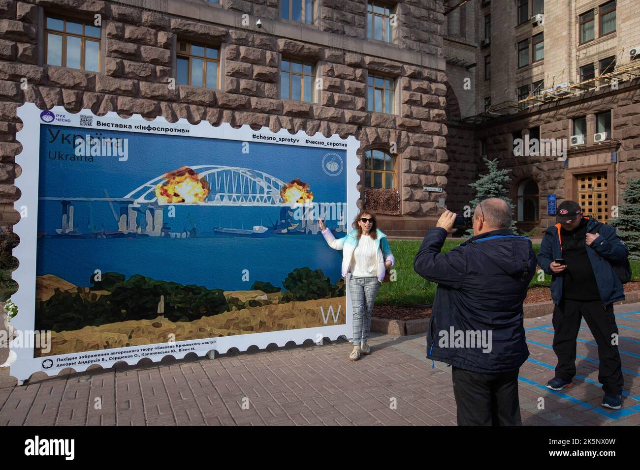 People are photographed with a stamp model depicting the burning ...