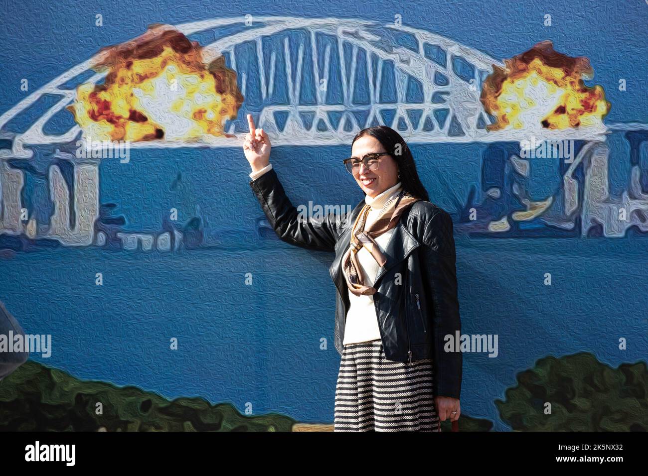 A woman poses for a photo with a stamp model depicting the burning ...