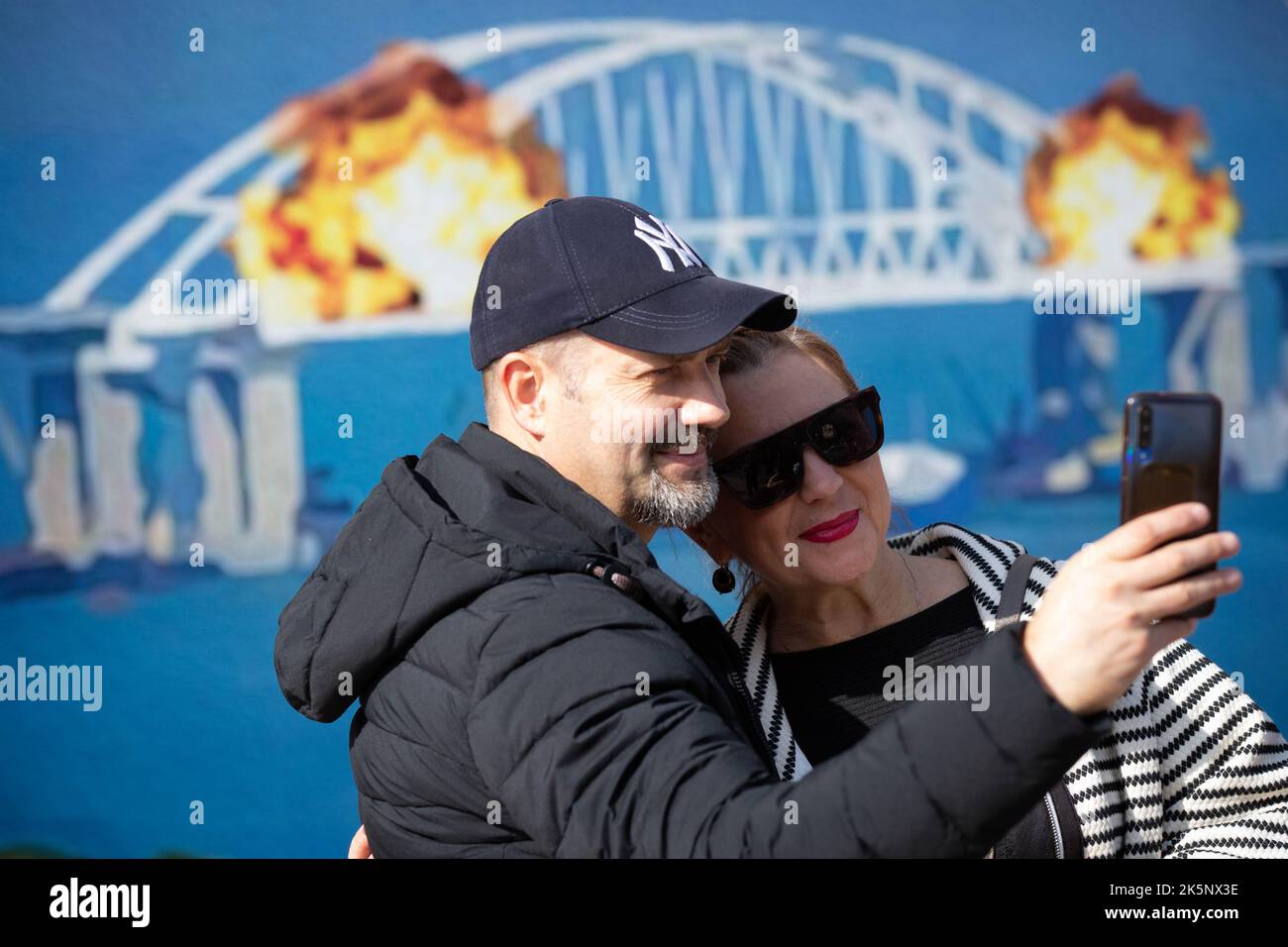 People are photographed with a stamp model depicting the burning ...