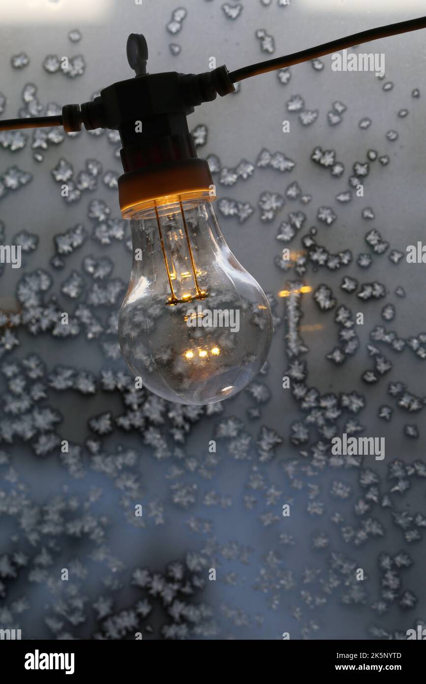 Decorative simple light bulb hanging on a balcony during a cold day ...