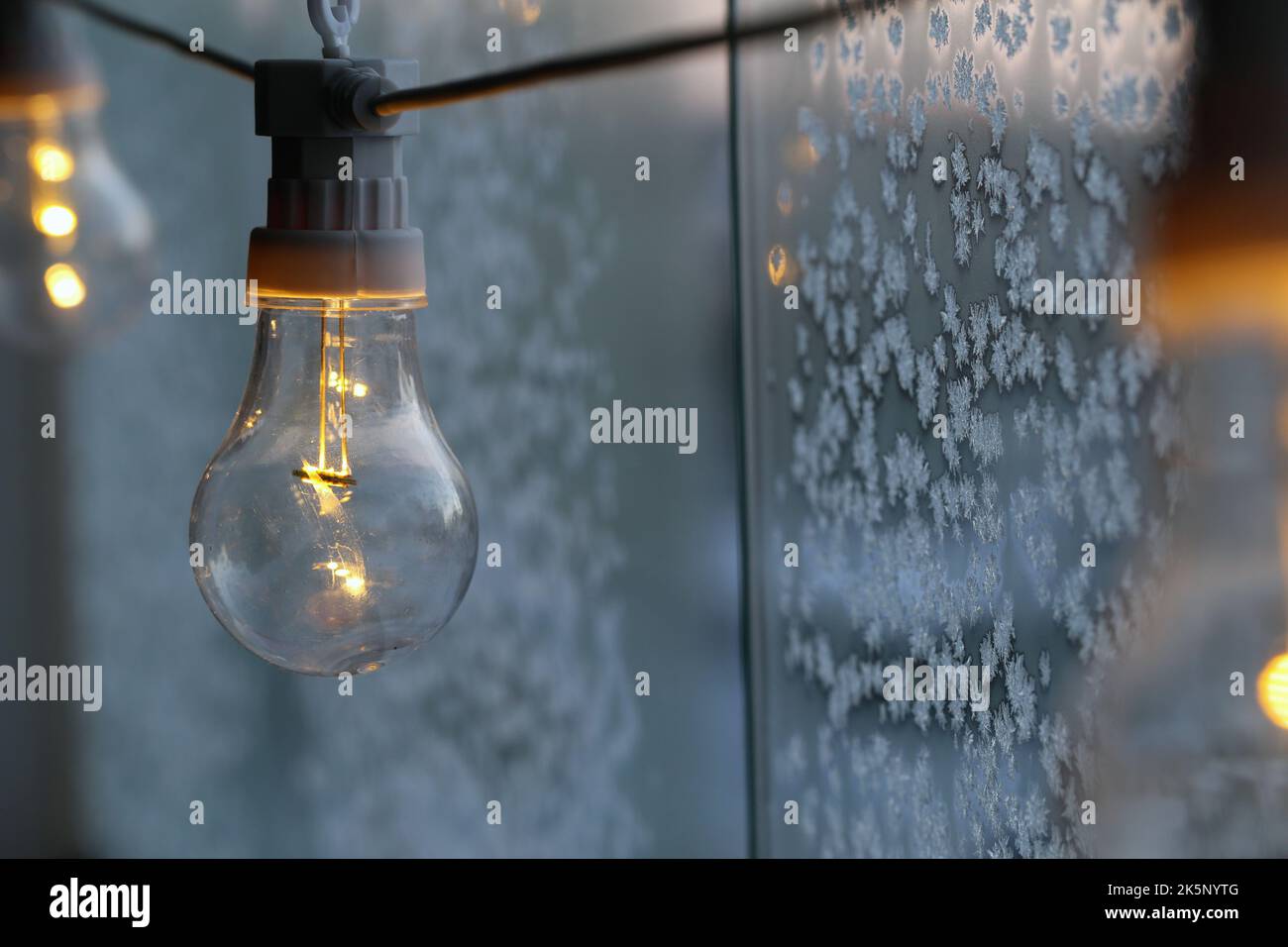 Decorative simple light bulb hanging on a balcony during a cold day ...