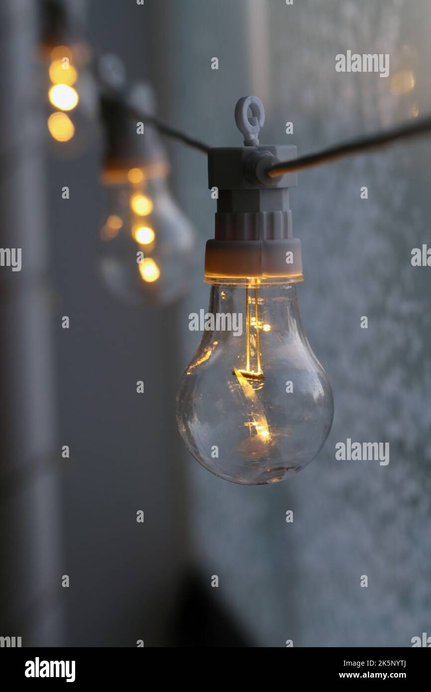 Decorative simple light bulb hanging on a balcony during a cold day ...
