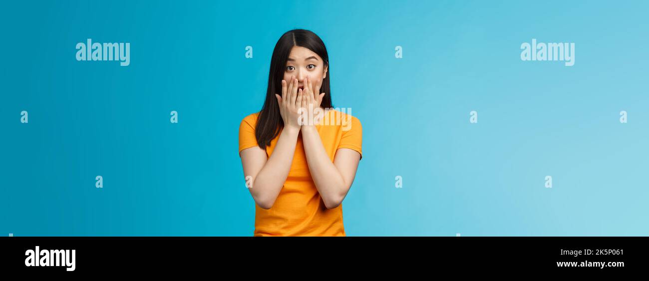 Shocked speechless stunned asian girl stare camera cover mouth palms ...
