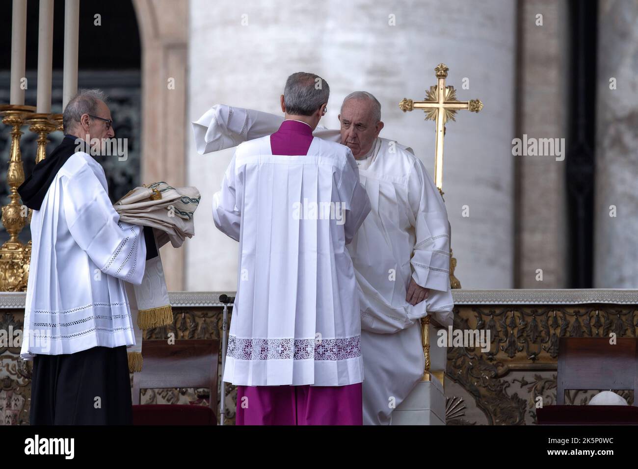 Vatican City, Vatican, 9 october 2022. Pope Francis is helped to wear ...