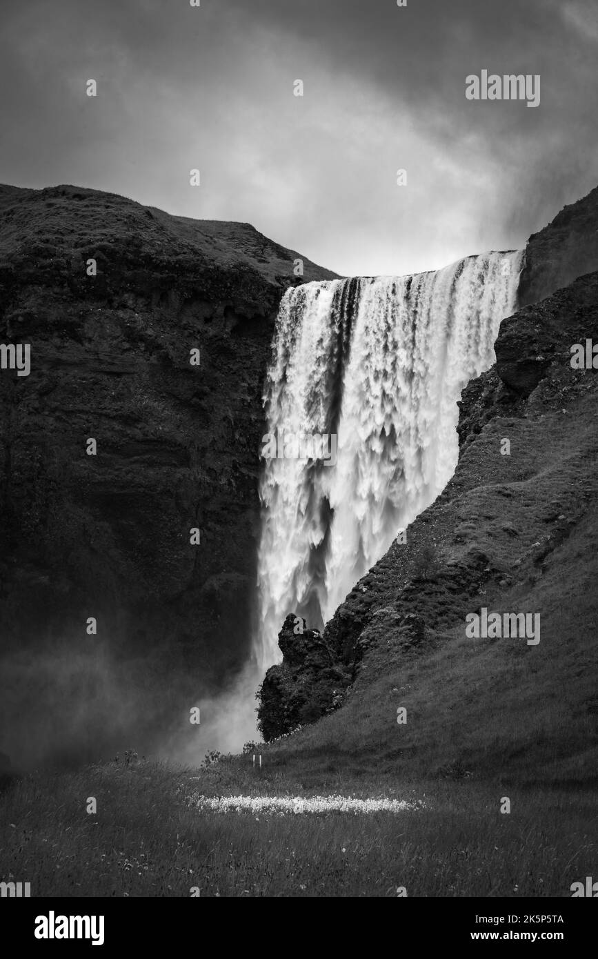 A mesmerizing scenery of a waterfall during the sunset in grayscale ...