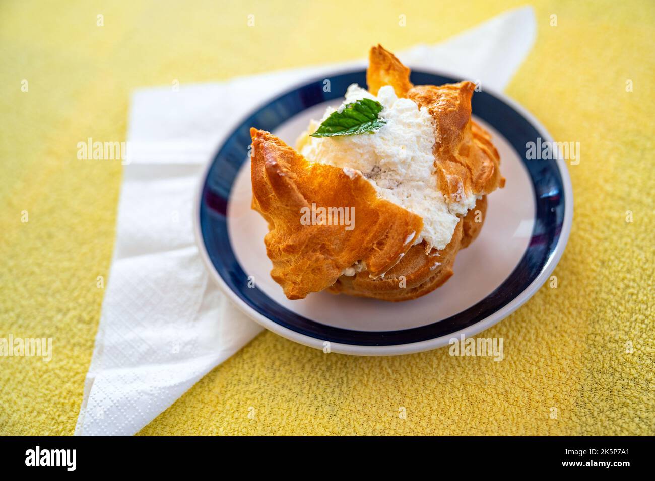 Light pastry dessert from battered dough with whipped cream and caramel ...