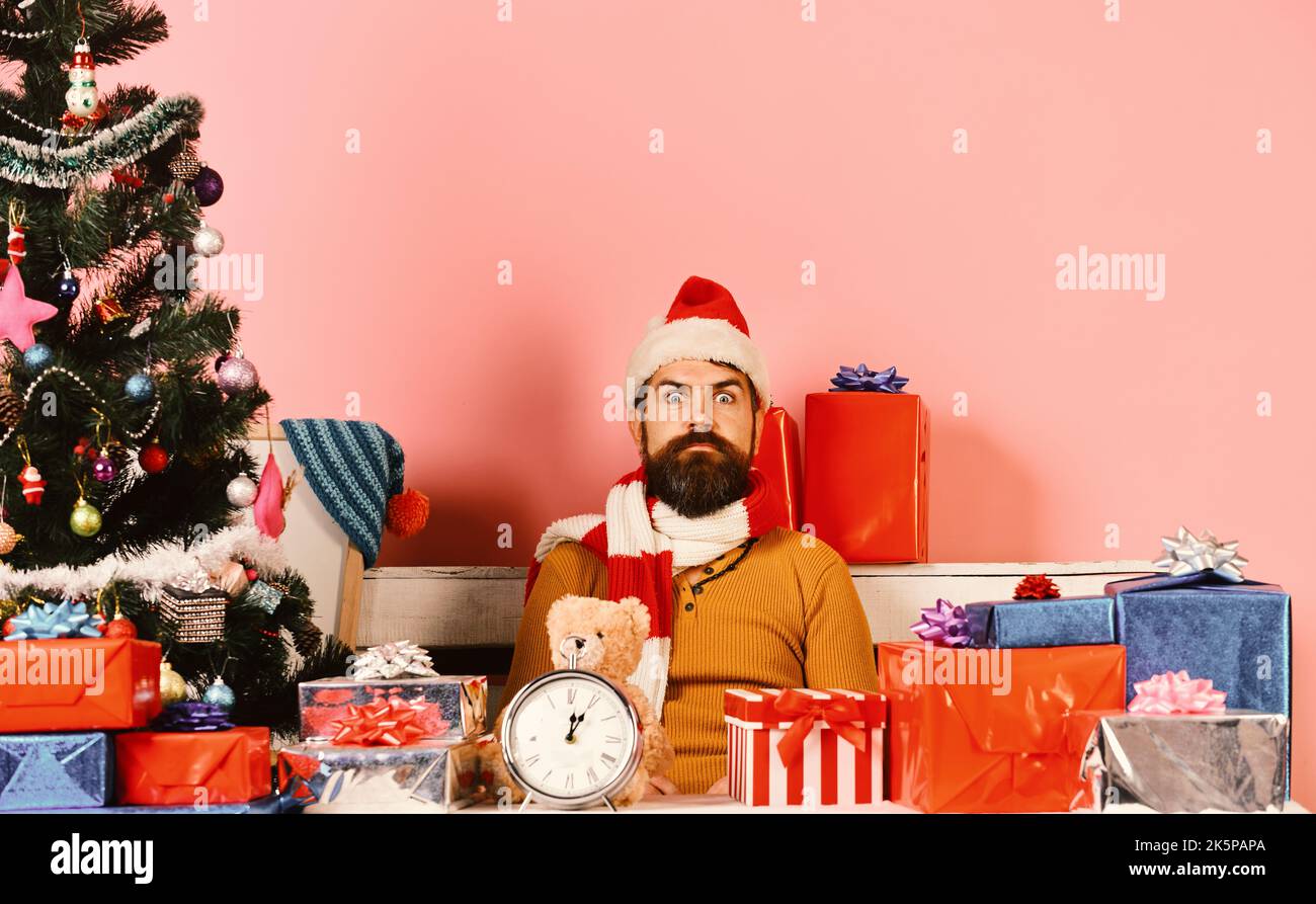Santa Claus waits for New Year near decorated tree Stock Photo - Alamy