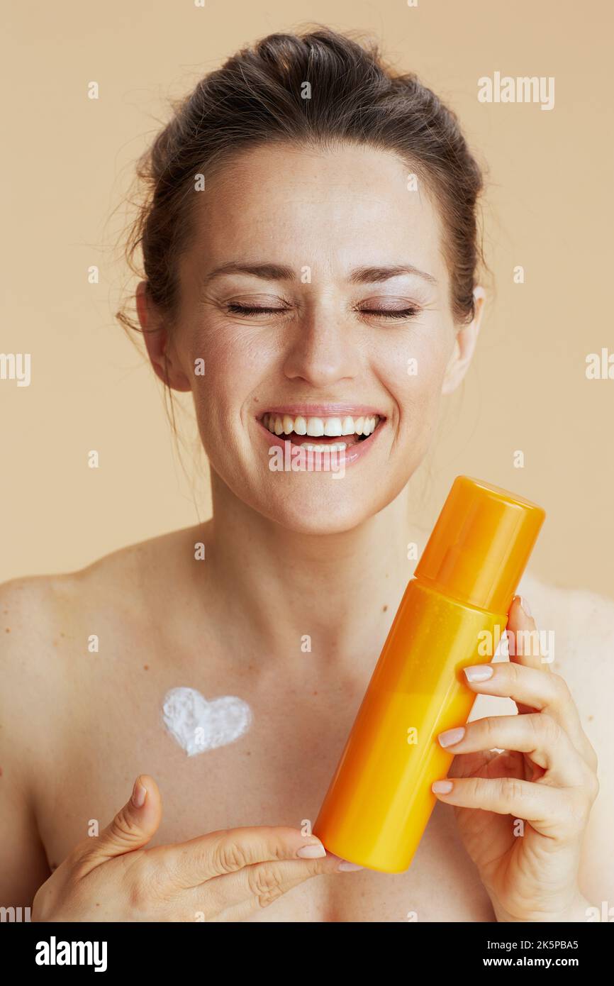 Happy 40 Years Old Woman With Cosmetic Cream Jar And Heart Shaped Cream