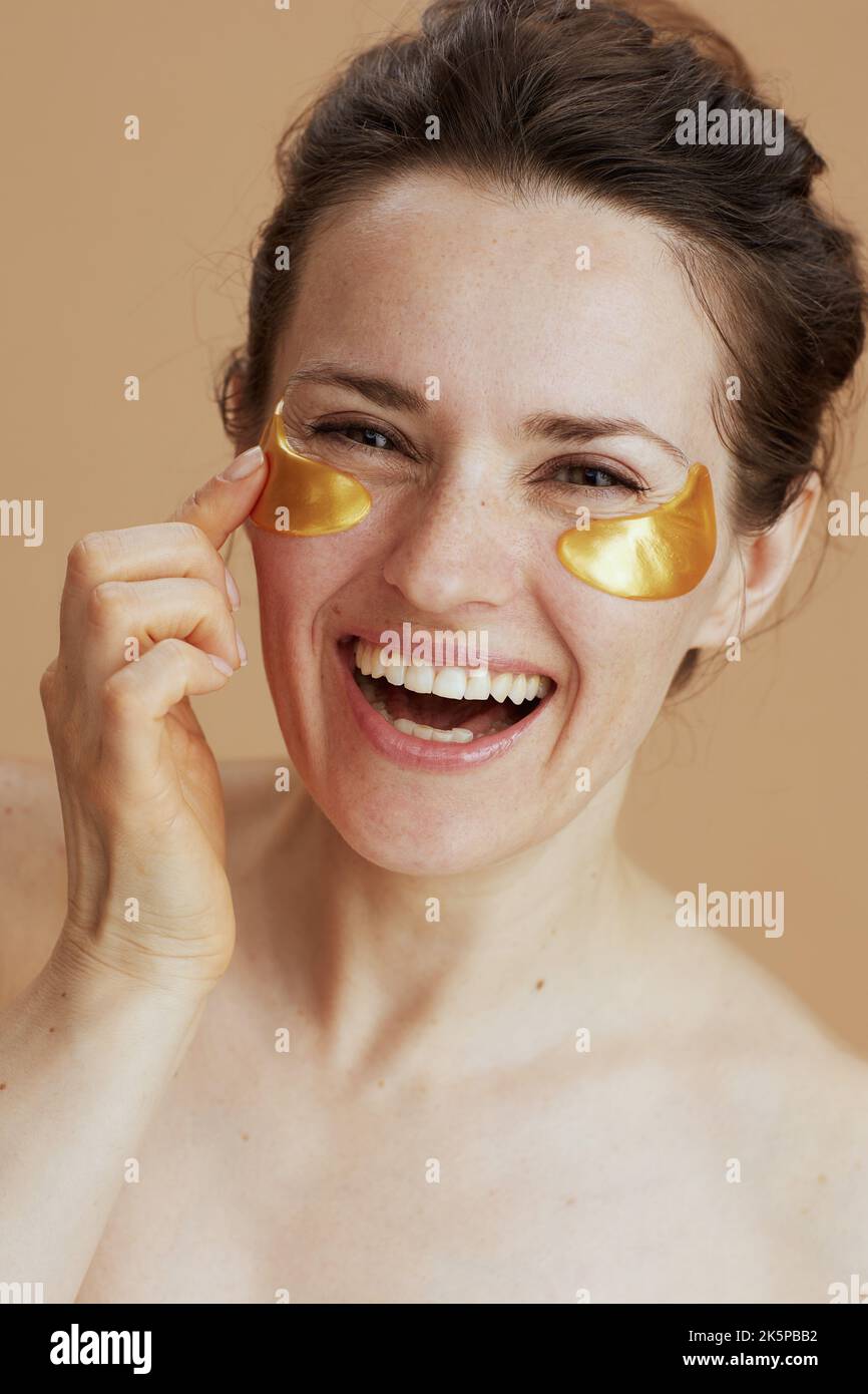 smiling modern female with eye patches against beige background Stock ...