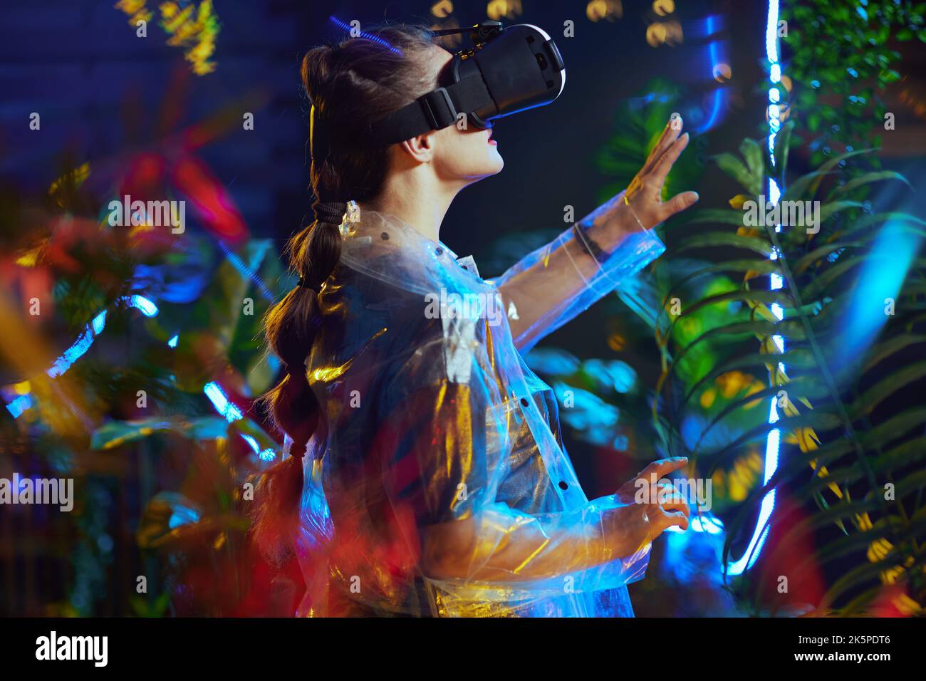 Seen from behind stylish 40 years old woman in virtual reality in vr ...
