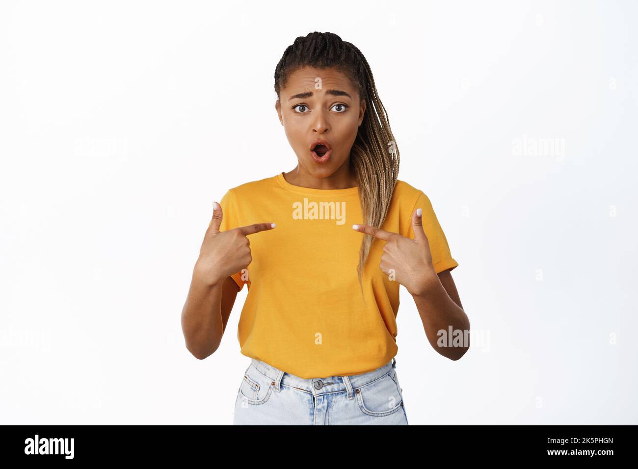 Shocked and confused Black teen girl pointing at herself, young woman ...