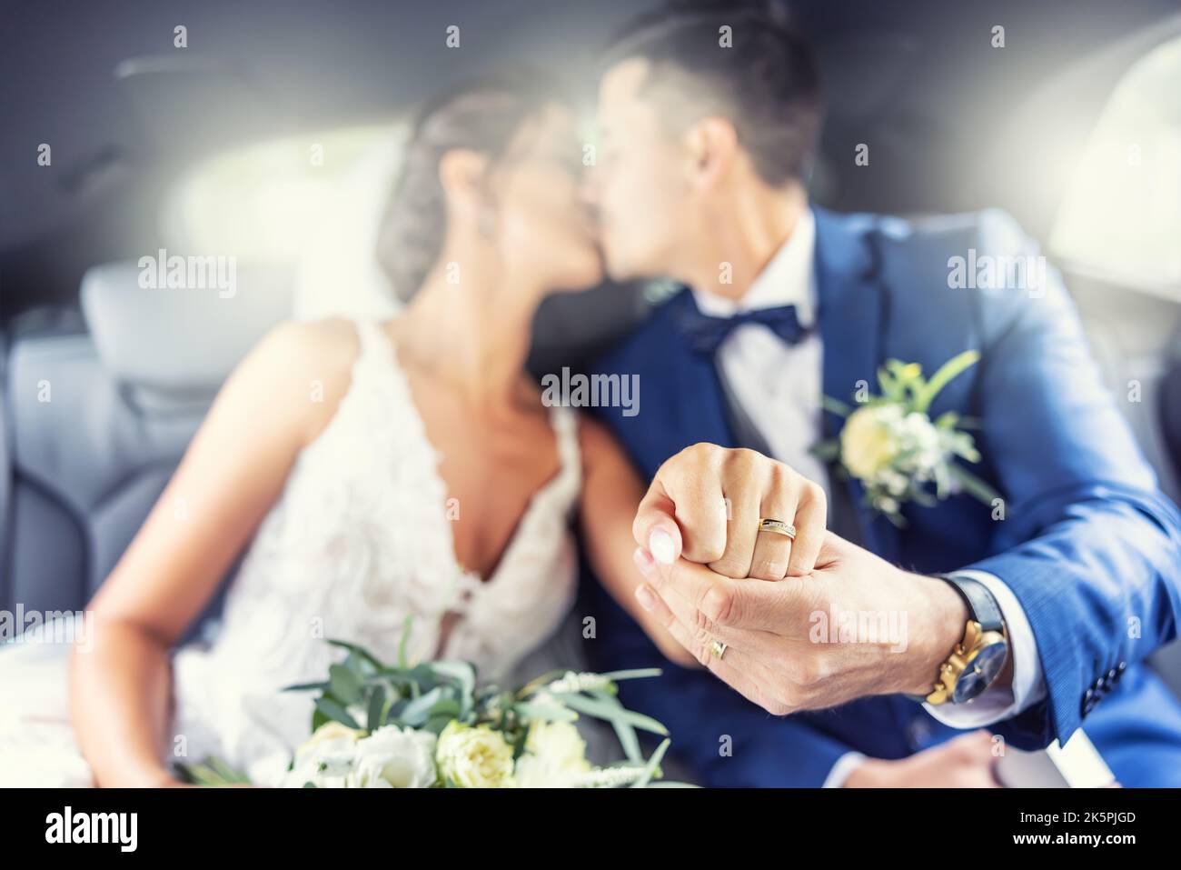 Just married couple kisses in the car showing rings on fingers towards ...