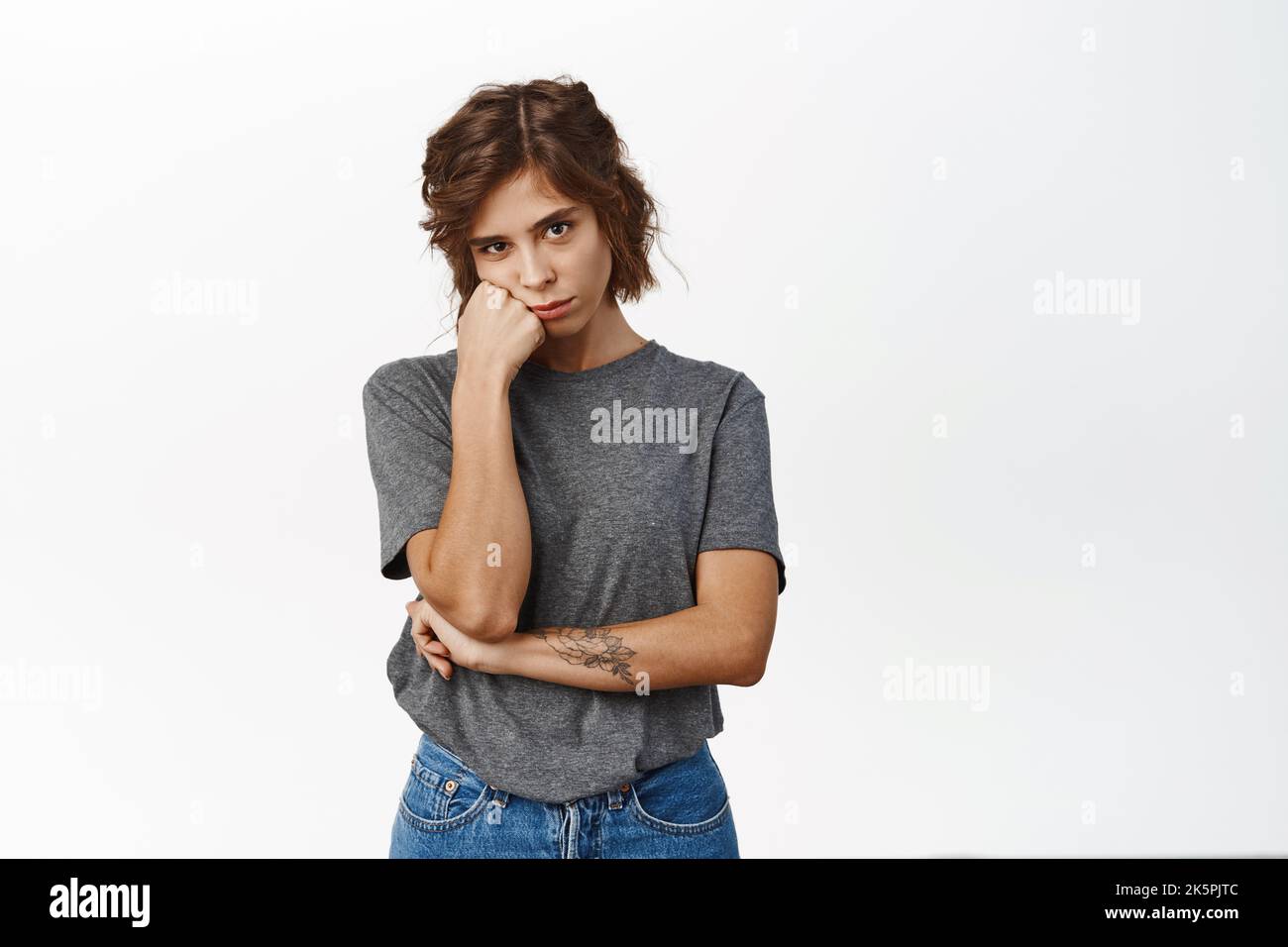 Sad or bored young woman looking upset, gloomy at camera, leaning head ...