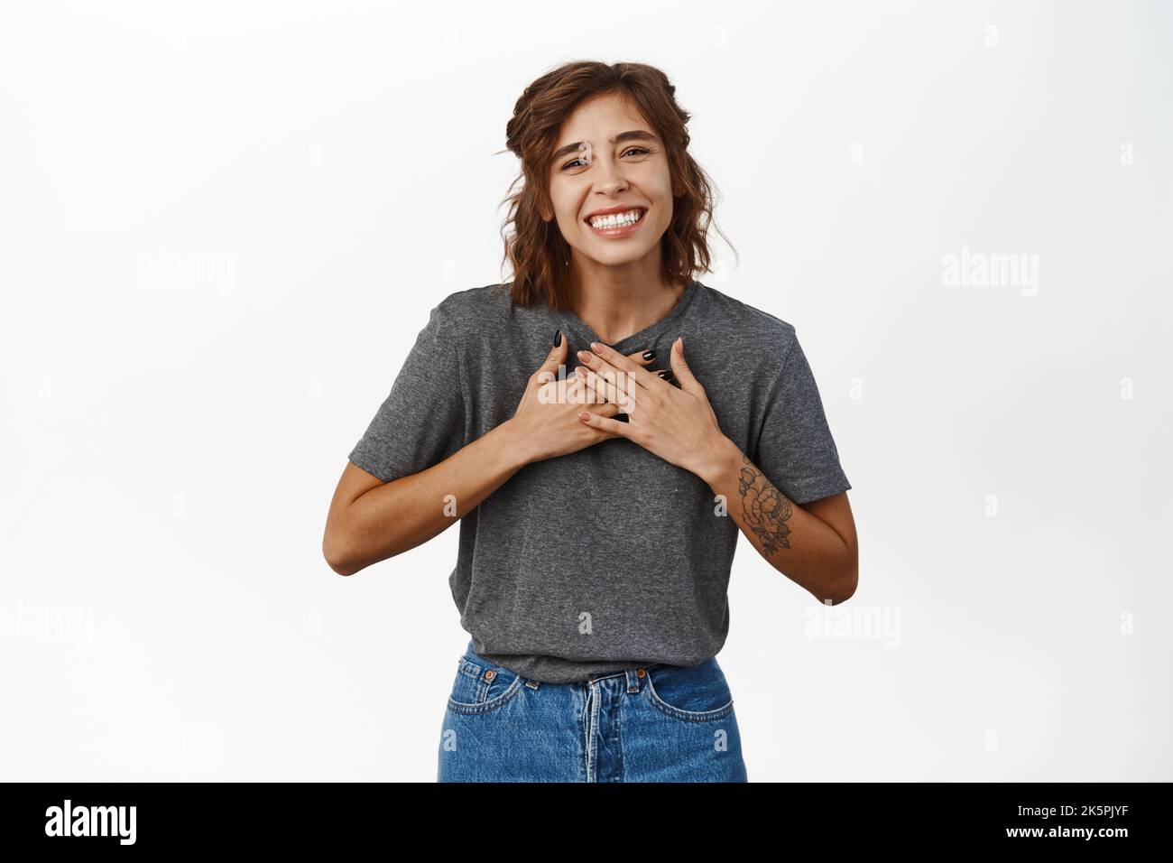 Happy young natural girl, holding hands on chest in appreciation pose ...