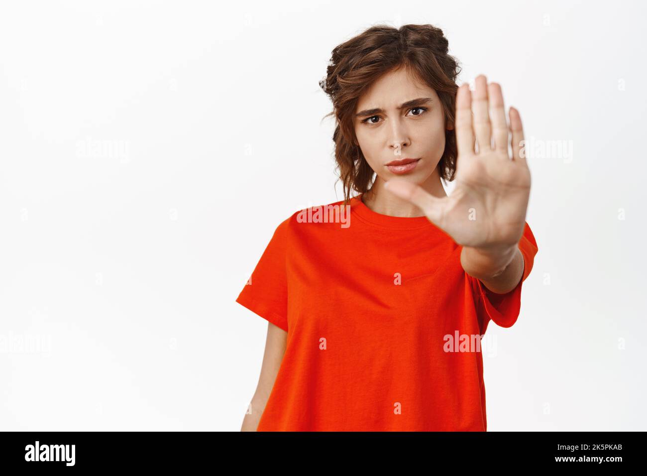 Image of serious young woman showing block, stop gesture, extending arm ...