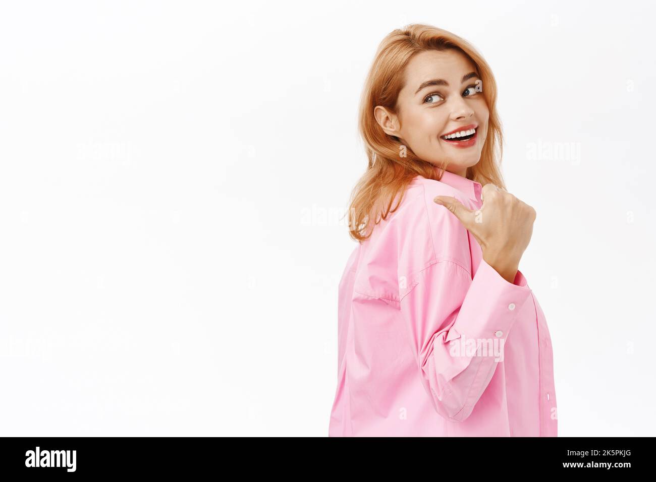 Portrait of healthy and happy young woman, pointing left and looking ...