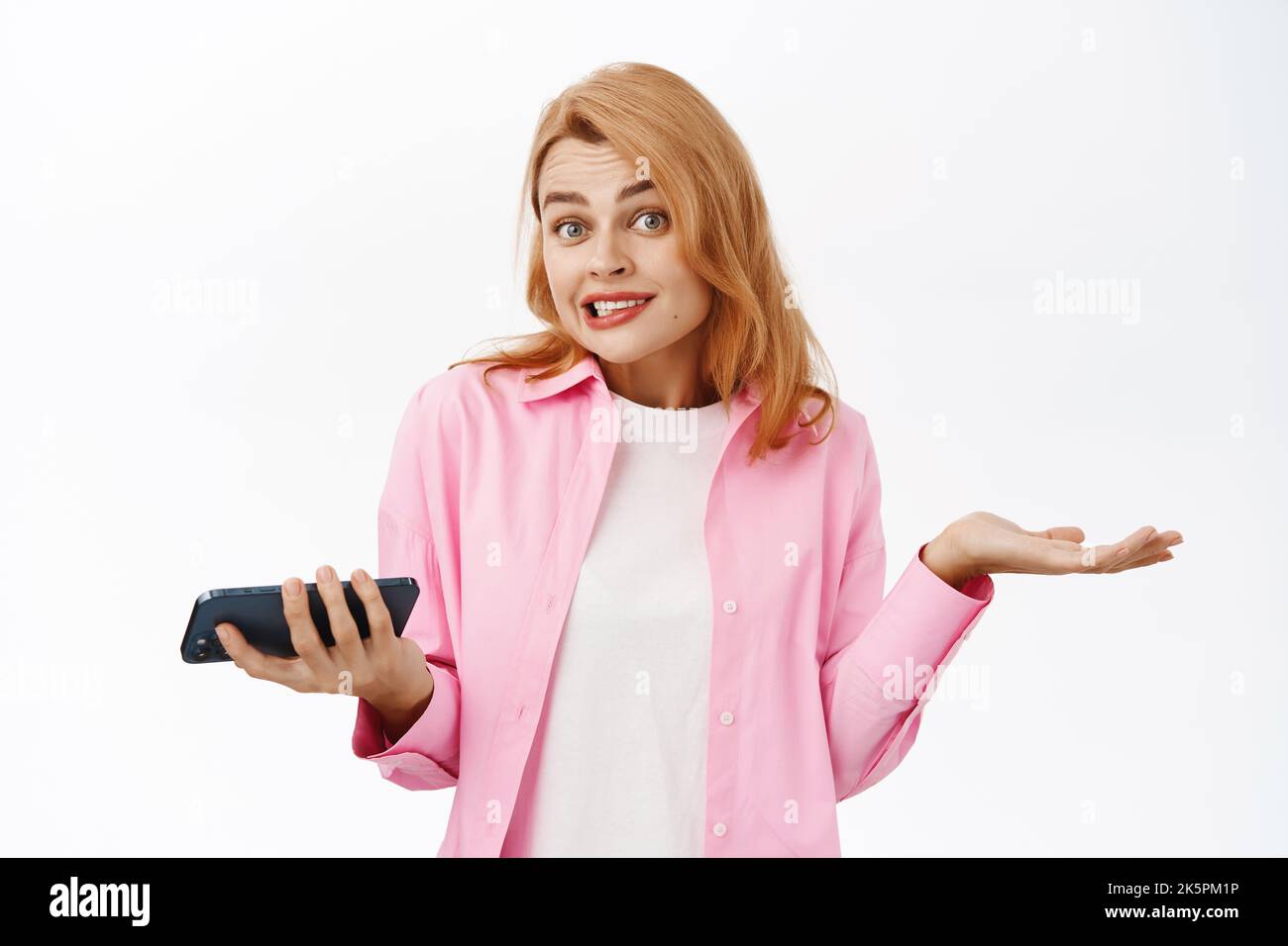 Oops, I dont know. Clueless woman shrugging shoulders with mobile phone ...