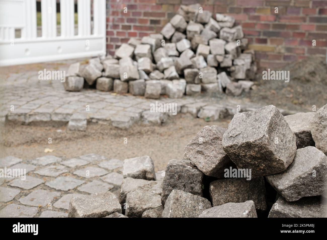 repair of paving stones of a pedestrian path on a city street in Europe ...