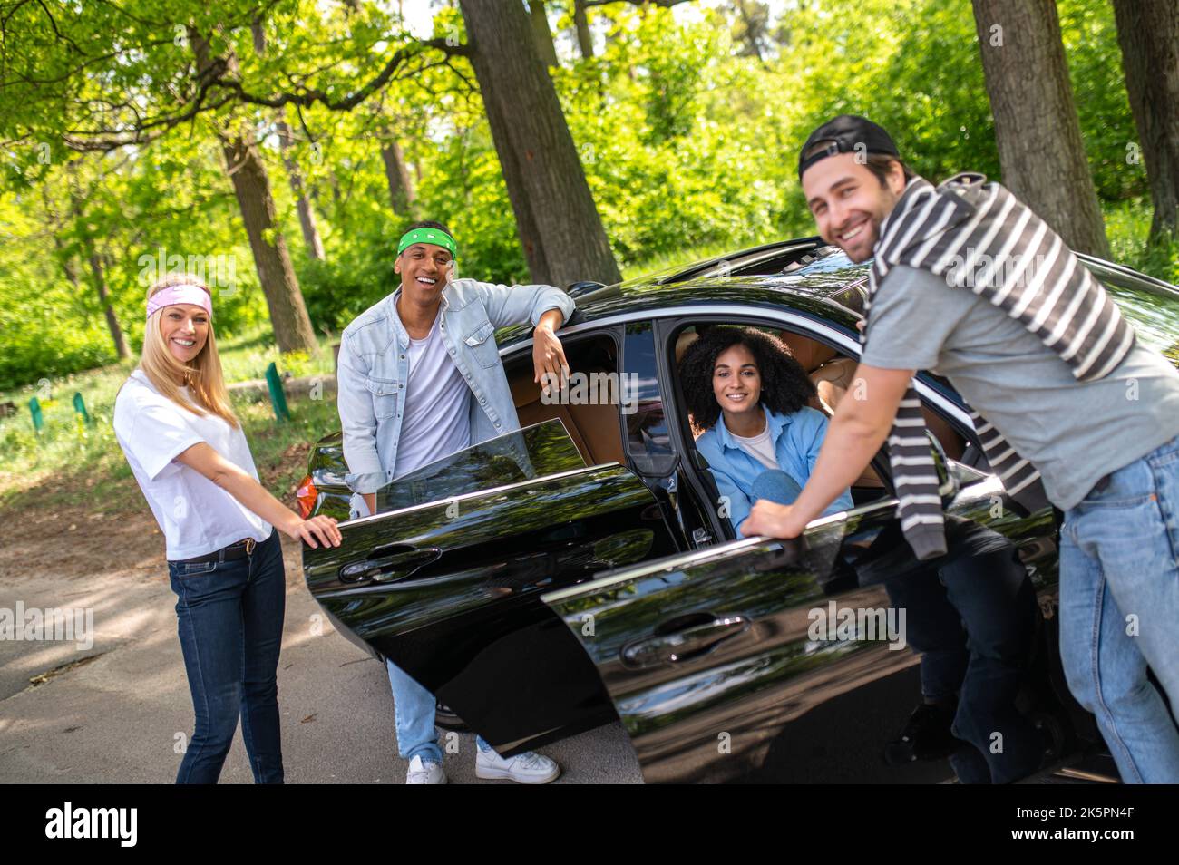 Group of young people discussing their car accident and making plan ...