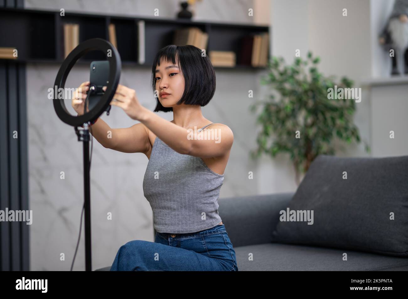 Focused female vlogger mounting the vlogging equipment Stock Photo - Alamy