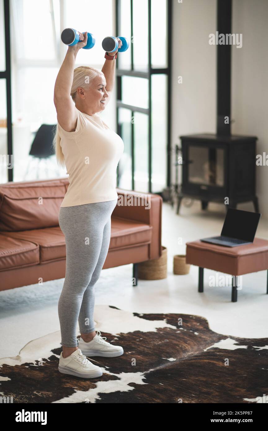 Cheerful female performing a strength training exercise indoors Stock ...