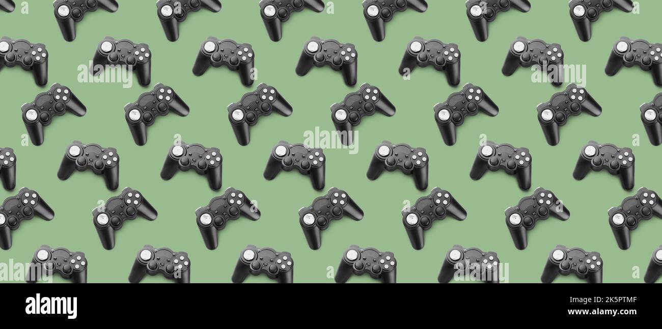 Many modern game pads on green background Stock Photo - Alamy