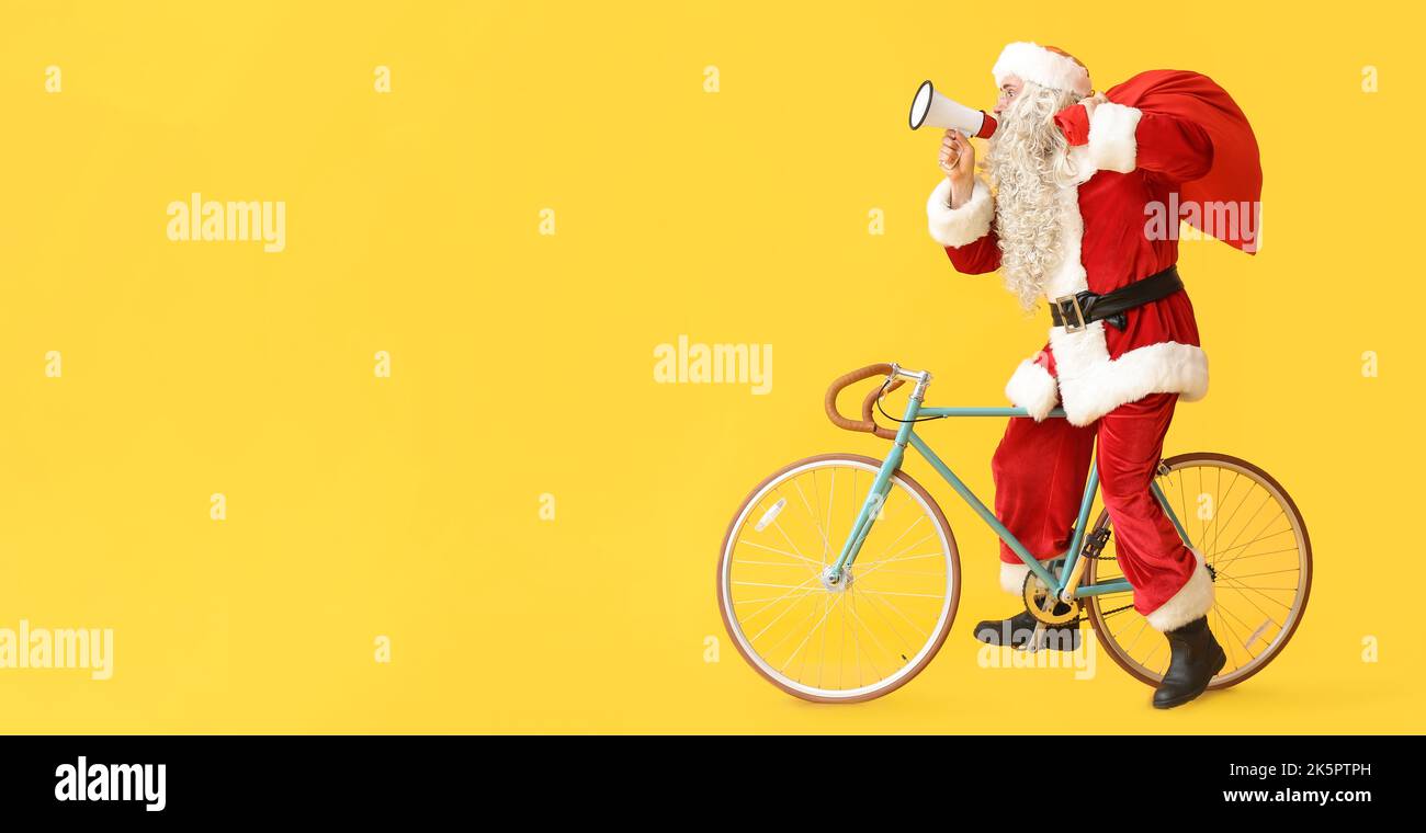 Santa Claus with megaphone riding bicycle on yellow background with ...