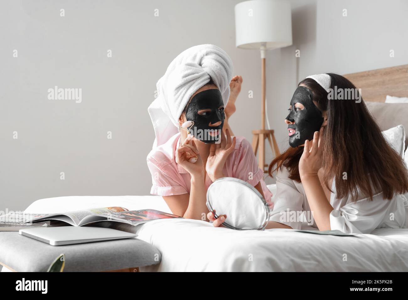Beautiful young women with activated charcoal sheet facial masks in ...