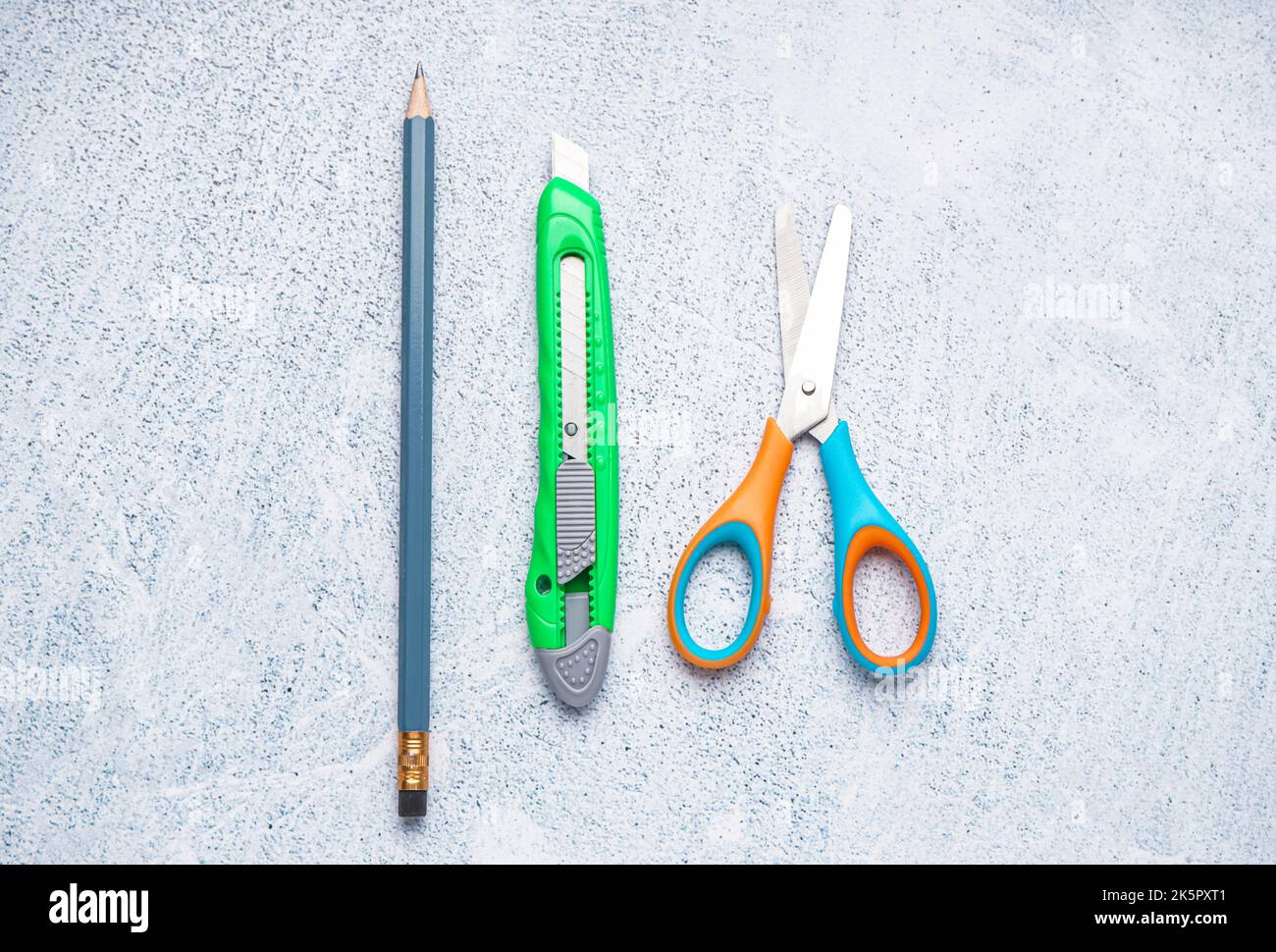 Utility knife with scissors and pencil on grunge background Stock Photo ...