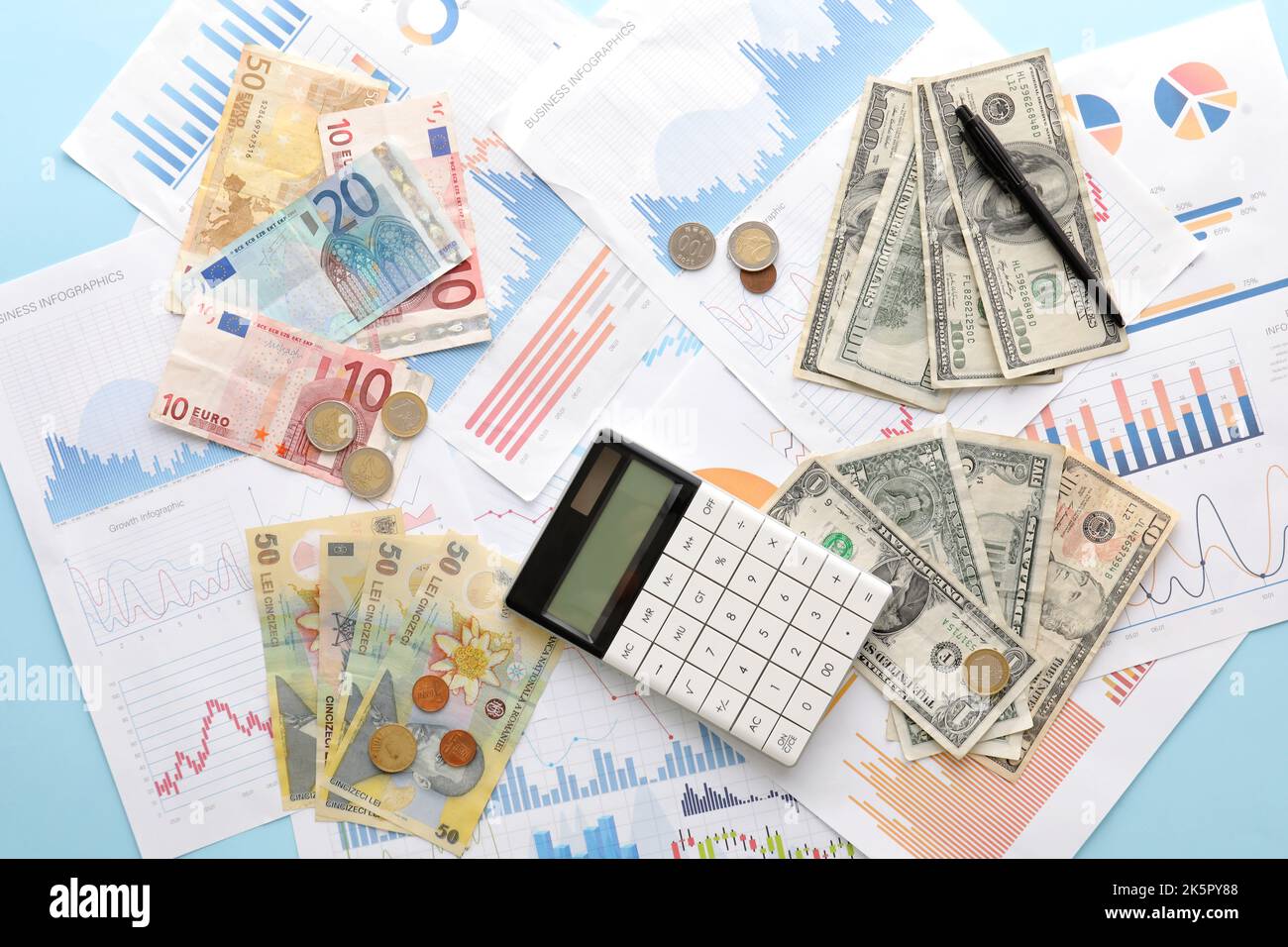 Different banknotes with coins, calculator, pen and diagrams on blue ...