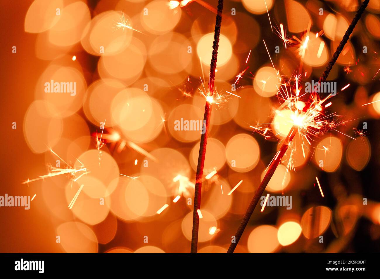 Sparkling bengal fire in the hands on shining bokeh background.Bengal ...