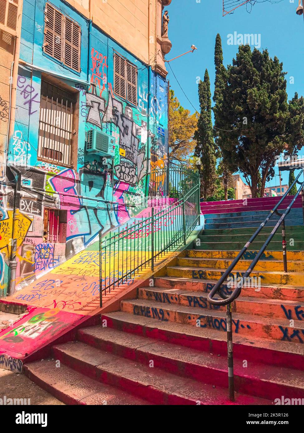 A vertical shot of colorful stairs and a building with graffiti in the ...