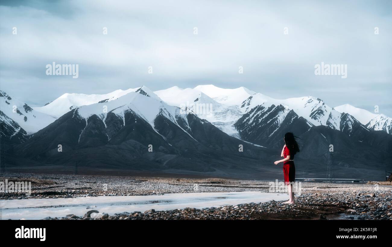 The Tanggula Snow Mountain in Qinghai Province, China with a woman ...