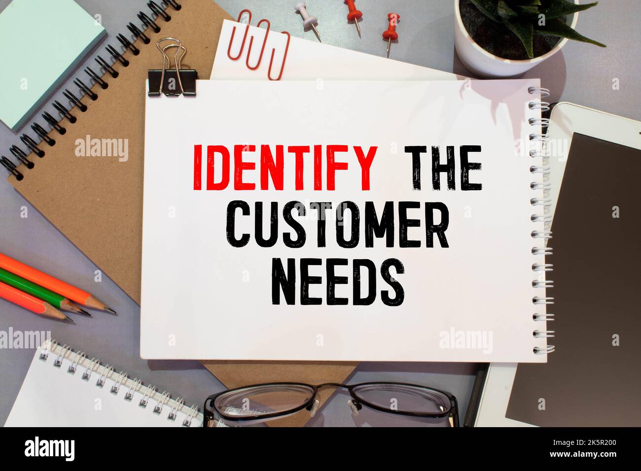 Notepad with IDENTIFY THE CUSTOMER NEED text on keyboard with felt-tip ...
